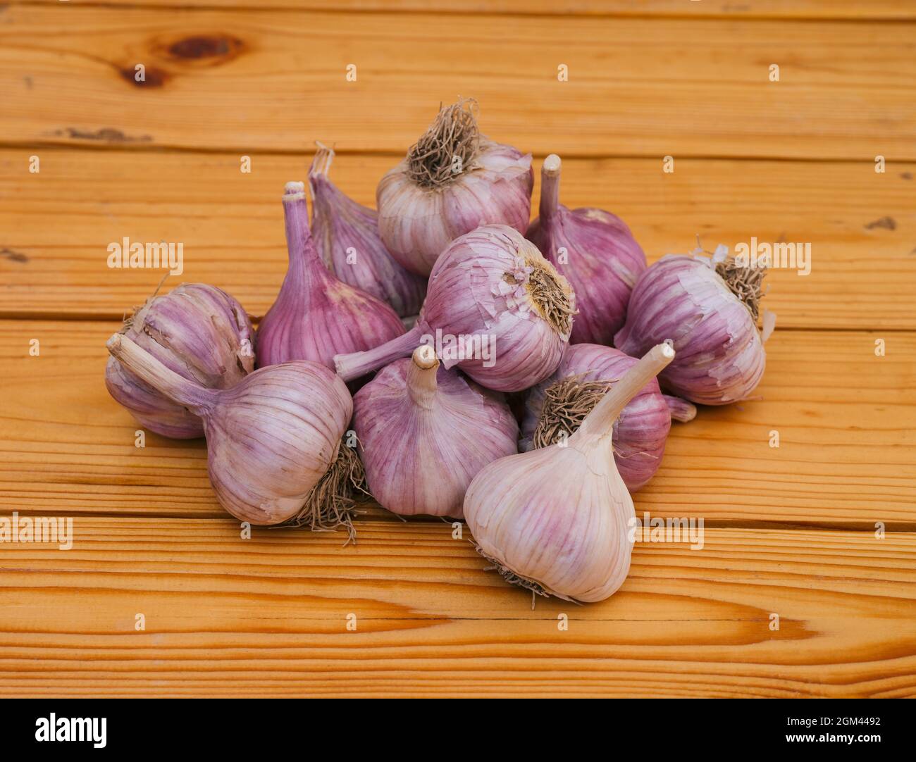 Heap of garlic on a wooden background Stock Photo - Alamy