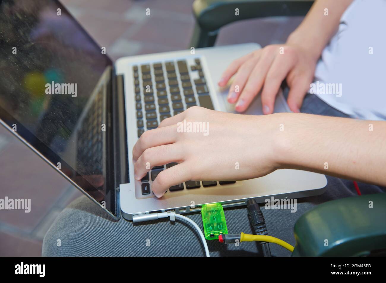 The boy is working on a computer on his lap . A cute Caucasian boy ...
