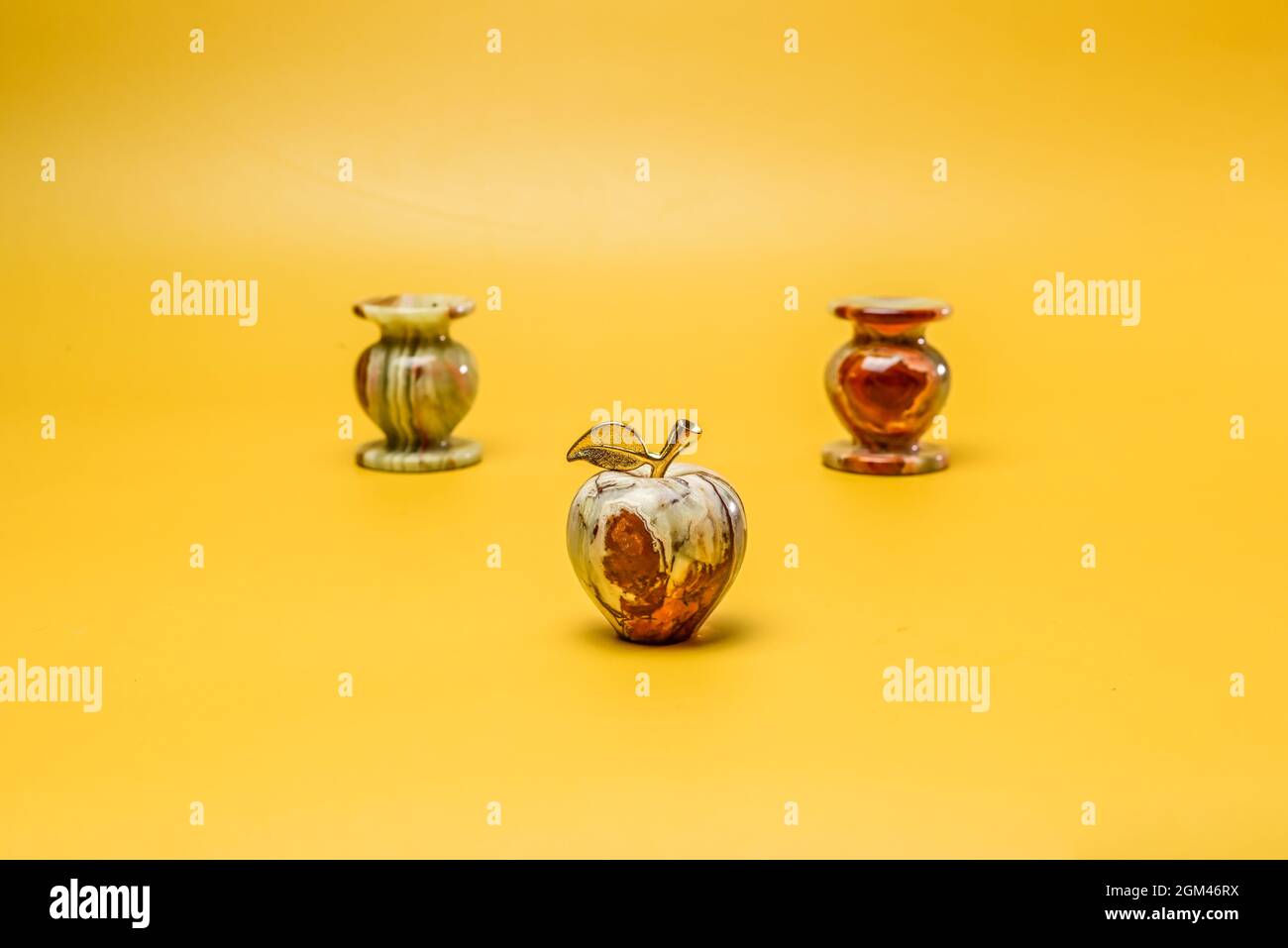 onyx stone apple on yellow background feng shui Stock Photo - Alamy