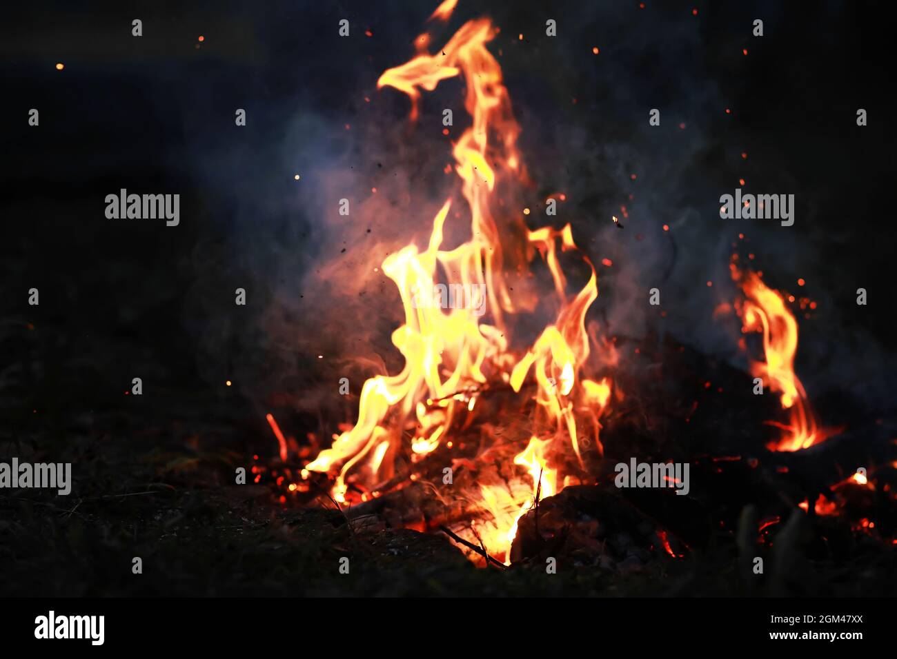 Burning red hot sparks fly from big fire. Burning coals, flaming ...