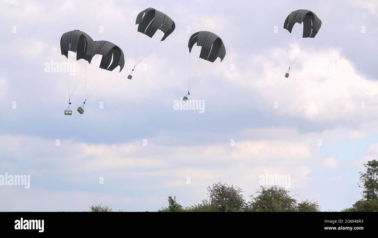 a line of parachute cargo glides down dropped from ZM401 an RAF Airbus ...