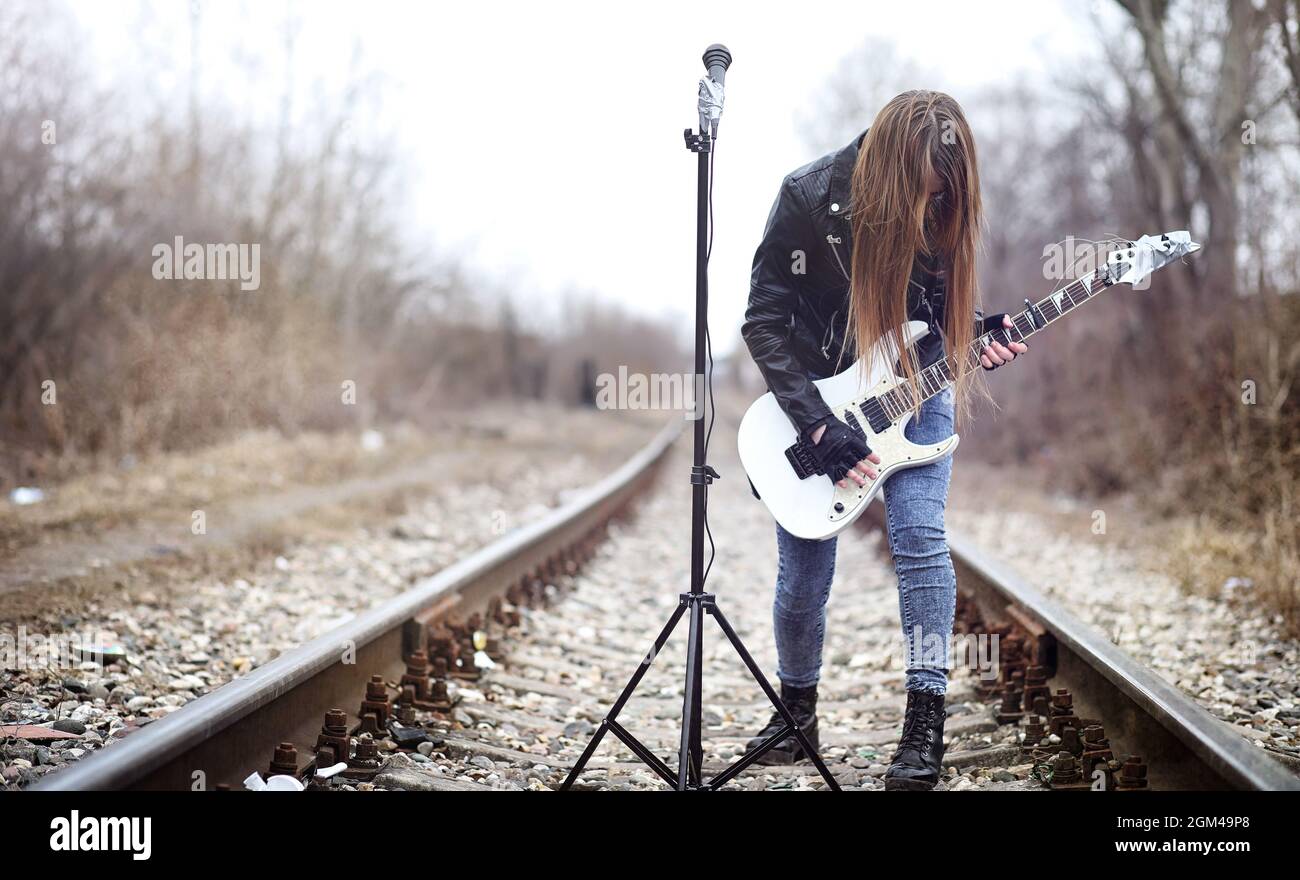 Beautiful young girl rocker with electric guitar. A rock musician girl ...