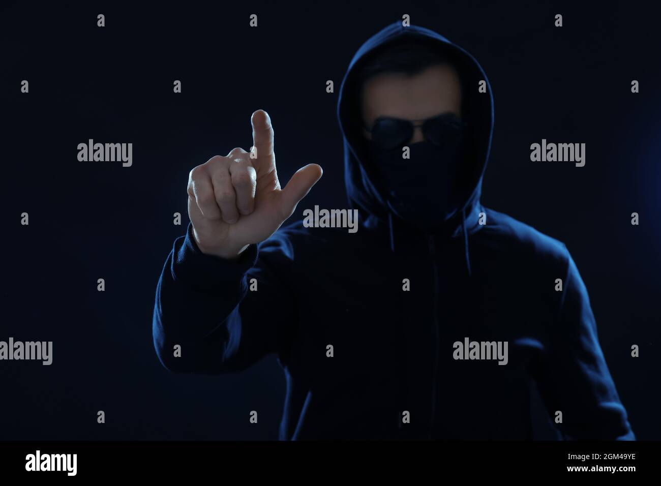 Hacker pushing button on virtual screen against dark background Stock ...