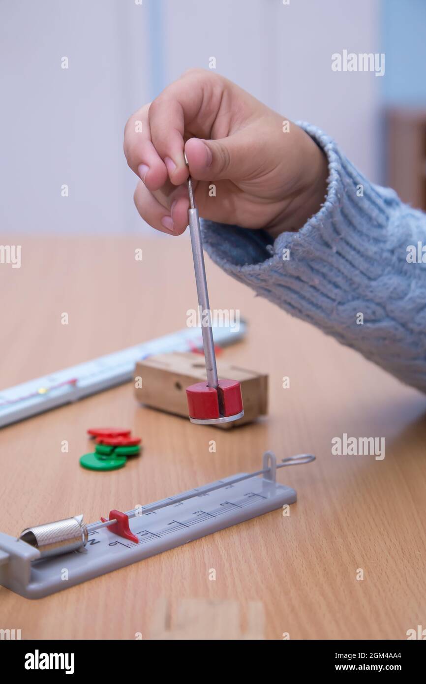 Close-up of a physical pendulum in a student's hand. A schoolboy ...