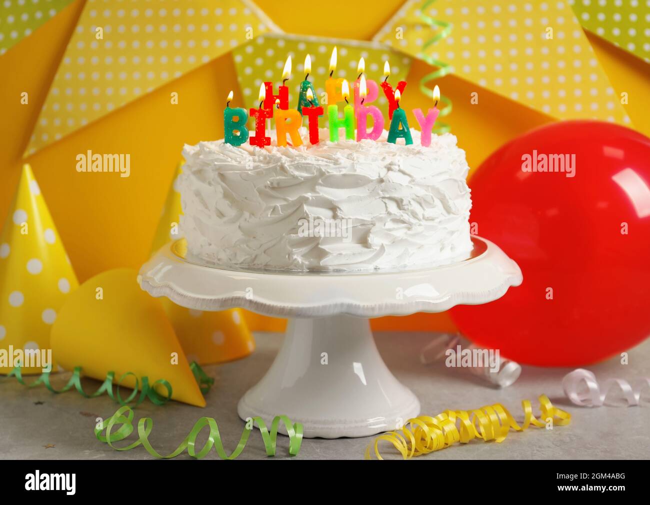 Stand with cake and "Happy birthday" candles on table Stock Photo - Alamy