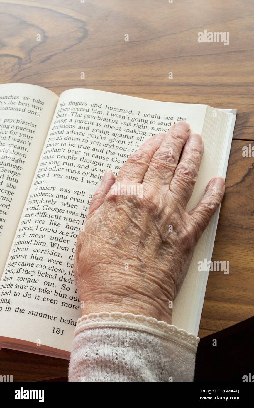 Elderly, visually impaired woman reading large print library book Stock ...