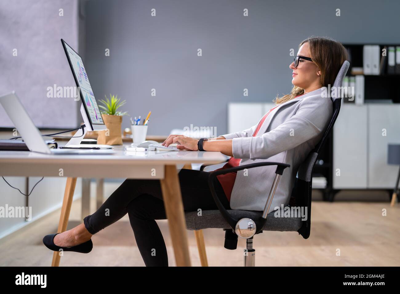 Woman Sitting In Bad Posture Working On Computer In Office Stock Photo ...