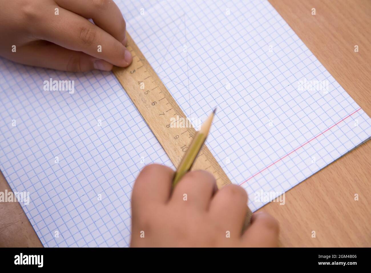 The student pressed a ruler to a notebook sheet, a pencil in his hand ...