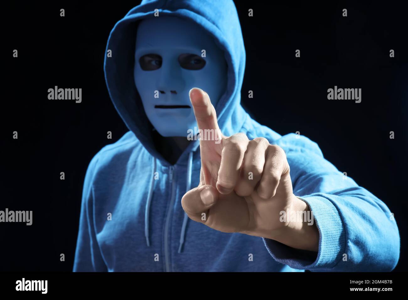 Hacker pushing button on virtual screen against dark background Stock ...