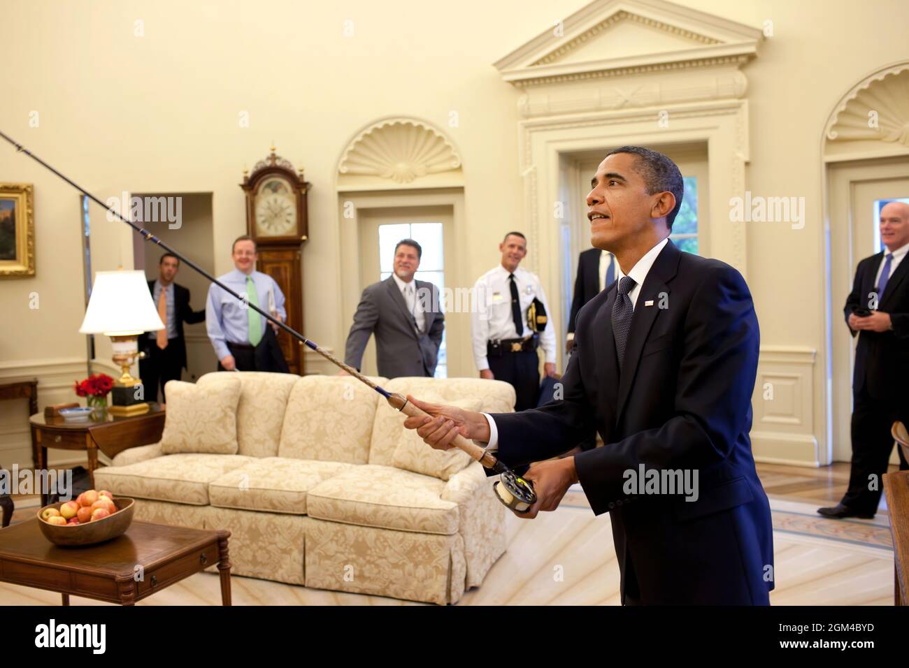 President Barack Obama tries out the fly fishing rod given to him on ...
