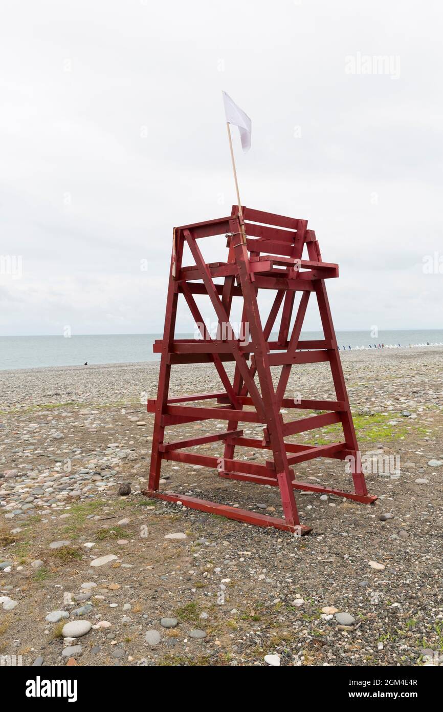 Red tower of lifeguards on a pebble beach in the resort town of Batumi ...