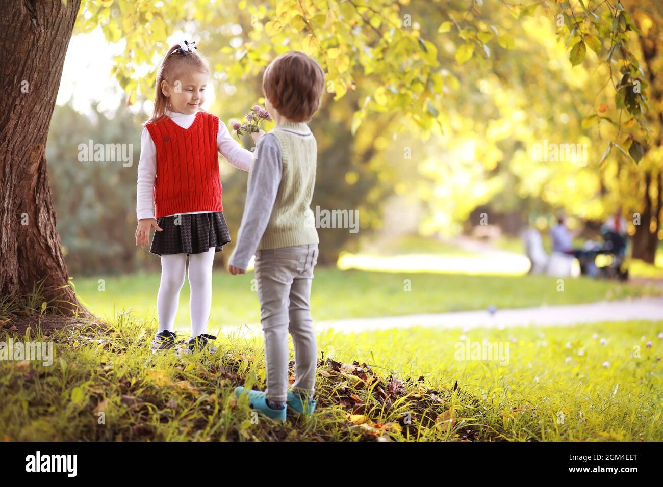 Children with briefcases for a walk in park. School break. The ...