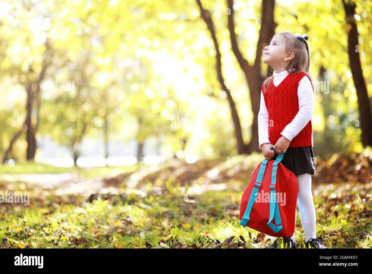 Children with briefcases for a walk in park. School break. The ...