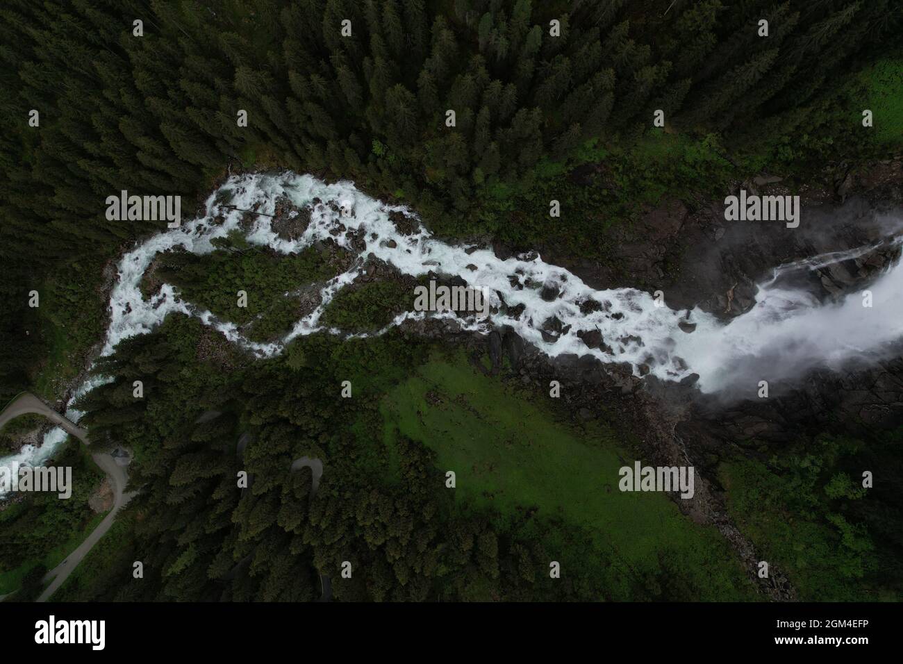 Bird's eye view of a river going down from a waterfall in a green ...