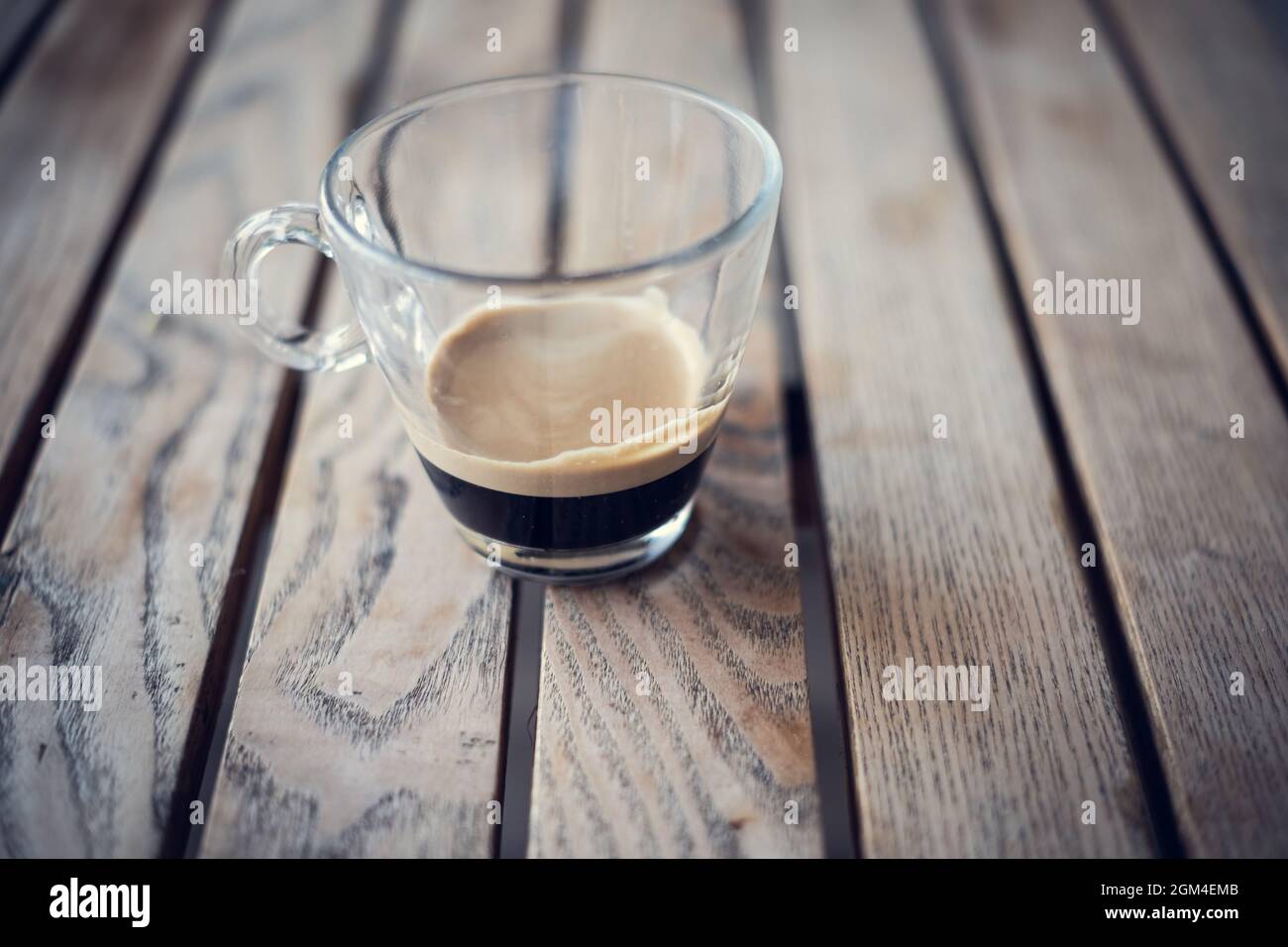 Short espresso coffee served on a transparent glass cup isolated on a ...