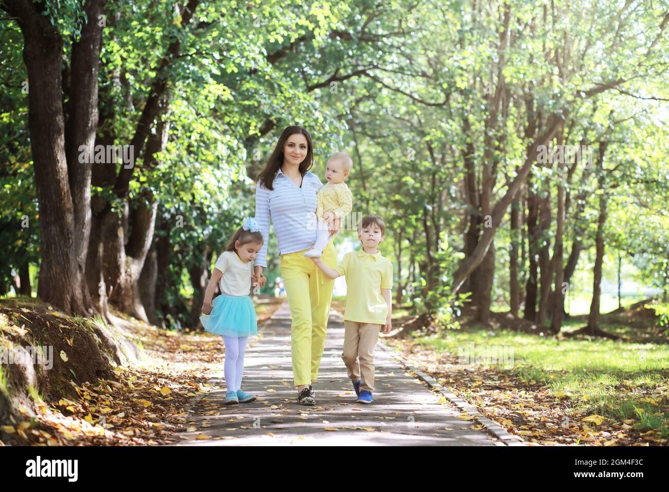 Family with children for a walk in the summer park. Сoming autumn in ...