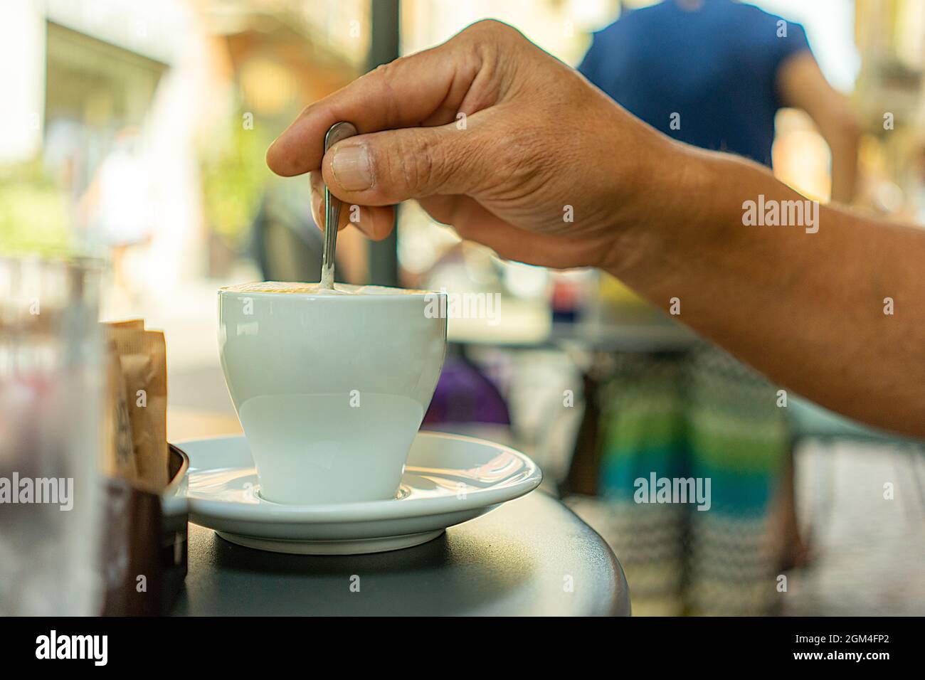 Closeup shot of a male's hand mixing coffee in a white cup Stock Photo ...