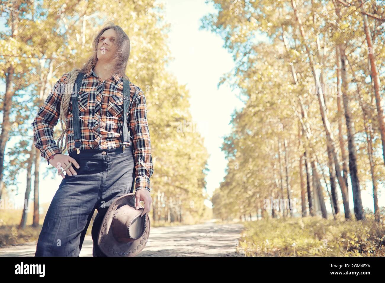 Cowboy with hat in a field in autumn Stock Photo - Alamy