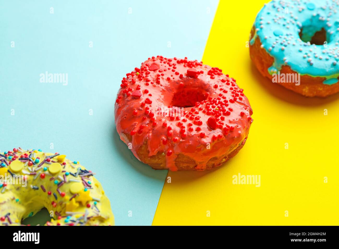 Delicious red donut on color background Stock Photo - Alamy
