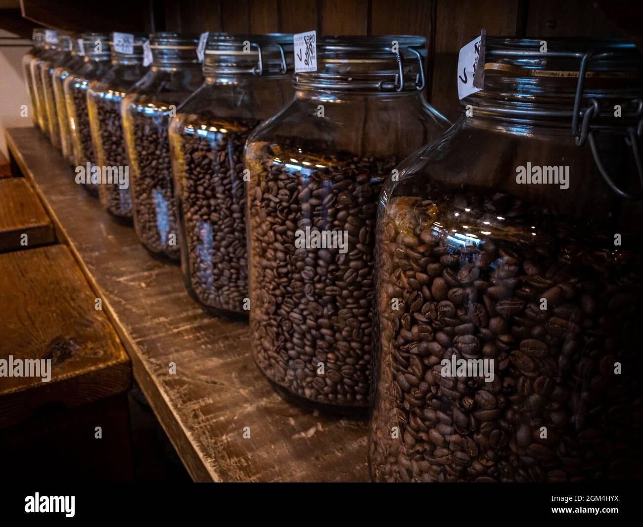 Black coffee beans glass jar packaging package on wood stand at caffe ...