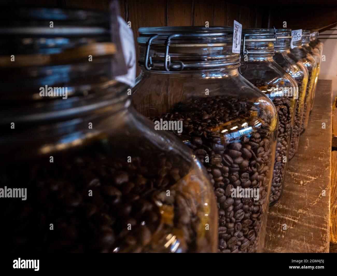 Black coffee beans glass jar packaging package on wood stand at caffe ...