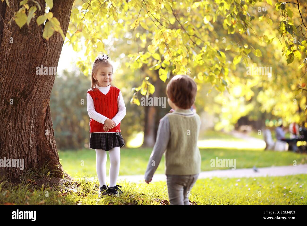 Children with briefcases for a walk in park. School break. The ...