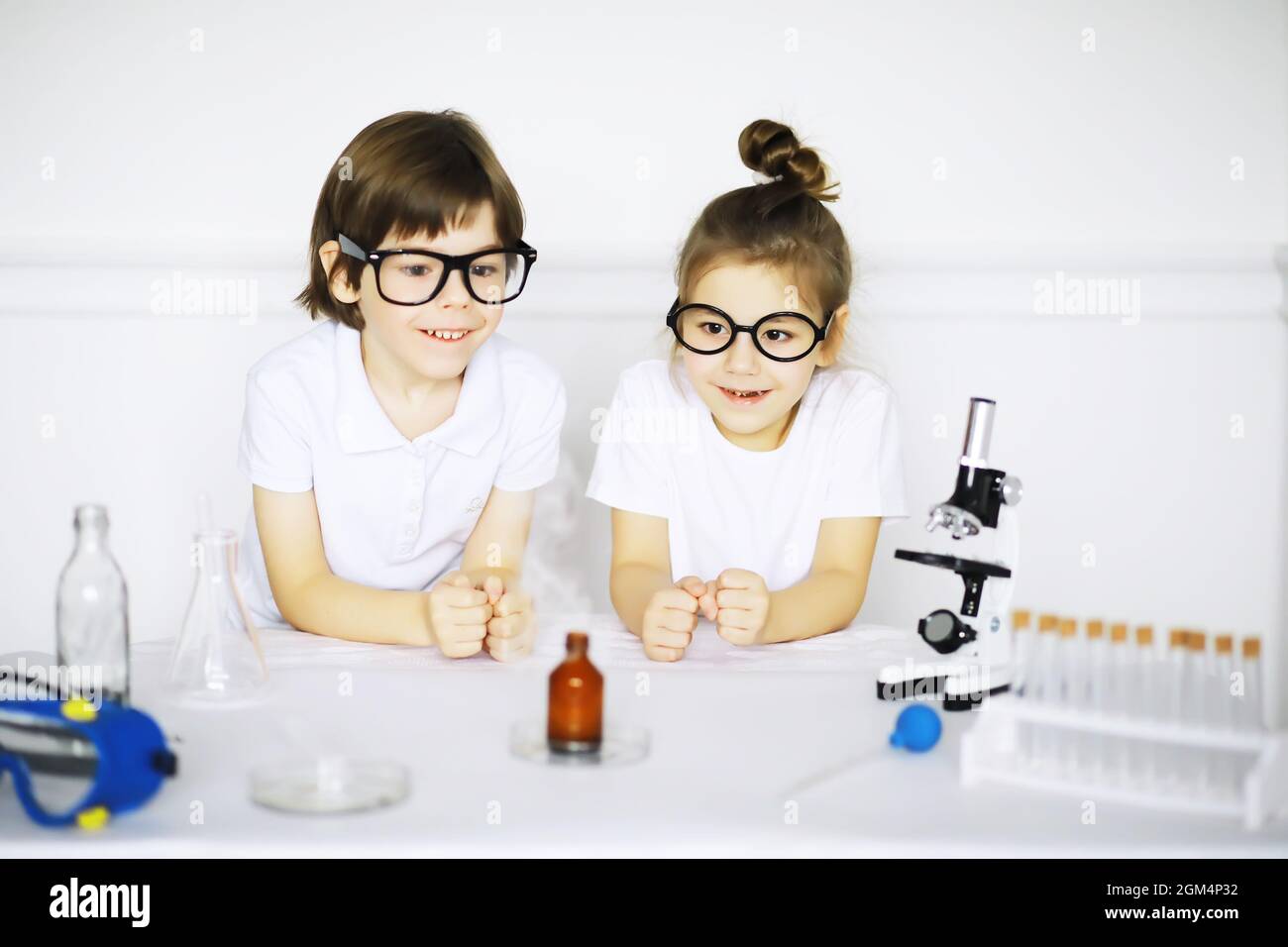 Two cute children at chemistry lesson making experiments isolated on ...