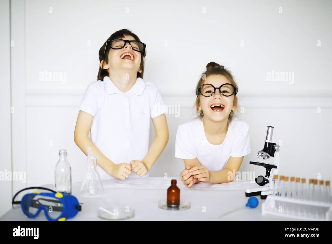 Two cute children at chemistry lesson making experiments isolated on ...