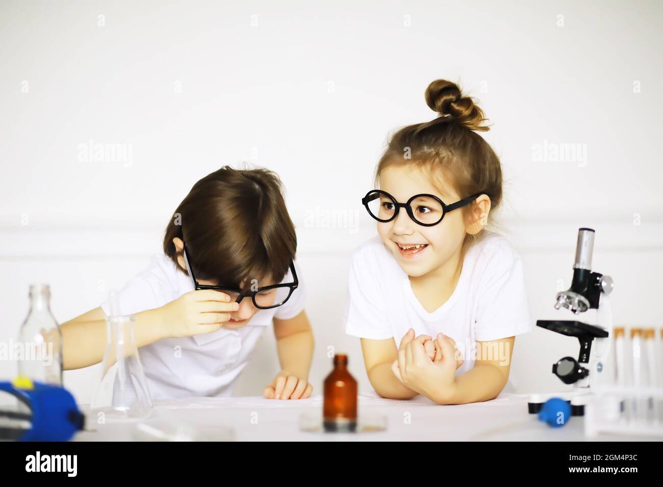 Two cute children at chemistry lesson making experiments isolated on ...