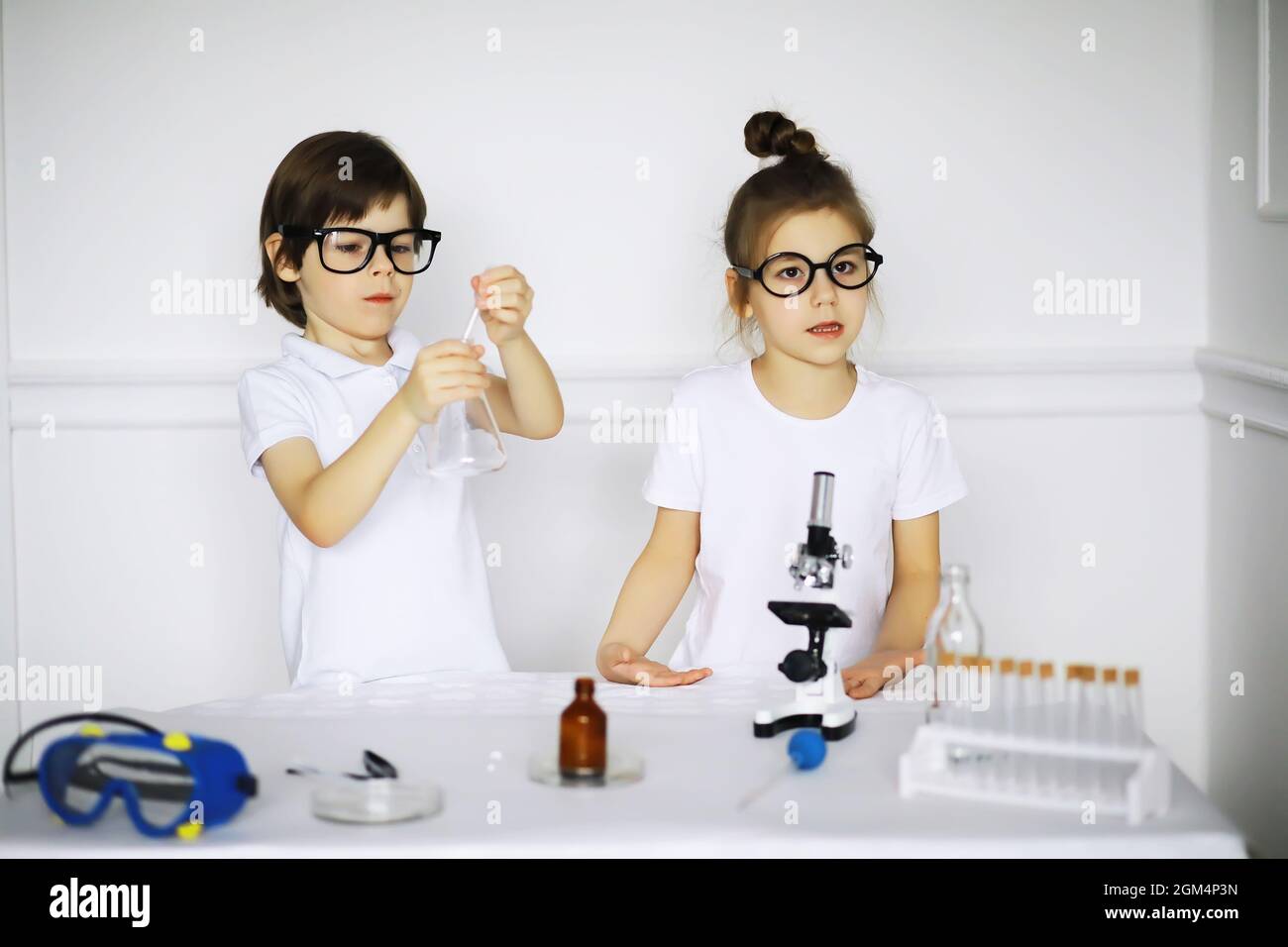 Two cute children at chemistry lesson making experiments isolated on ...