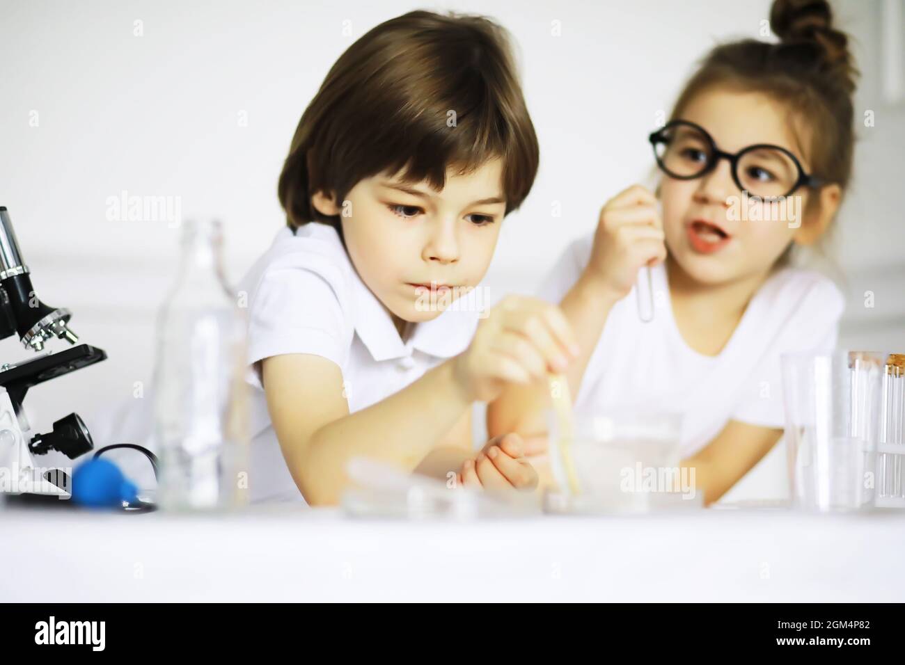 Two cute children at chemistry lesson making experiments isolated on ...