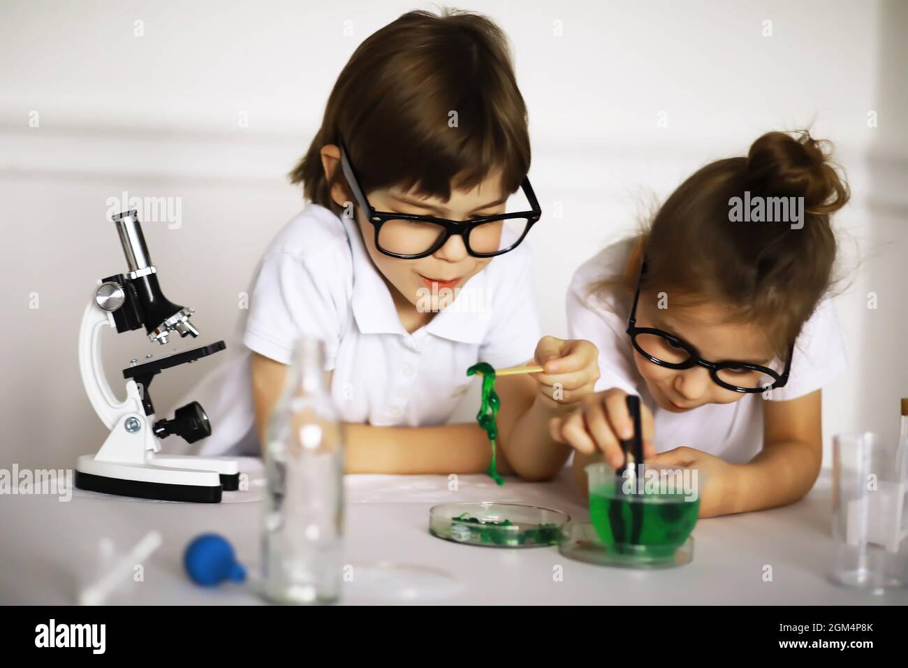 Two cute children at chemistry lesson making experiments isolated on ...