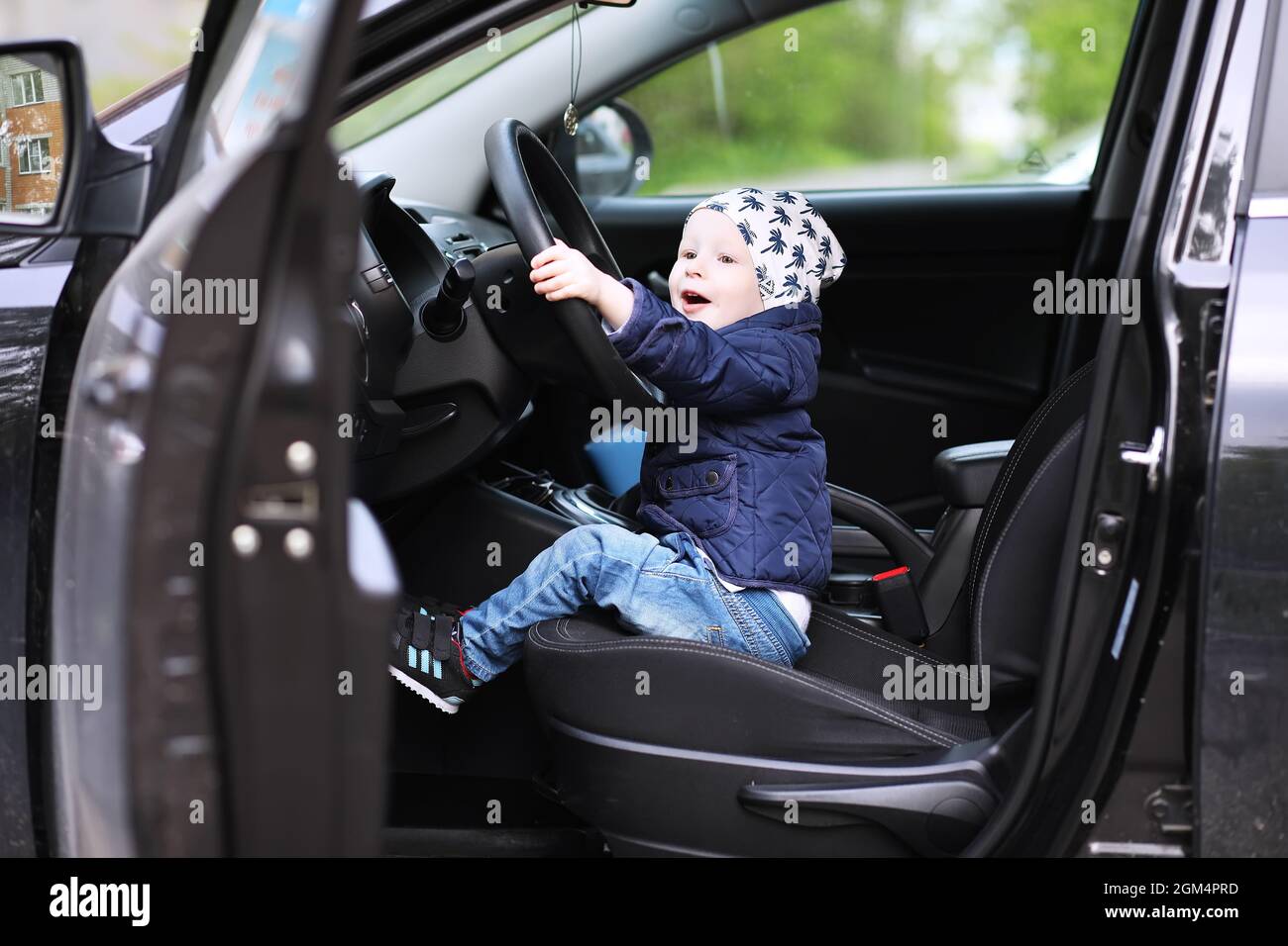 Little boy playing with a steering wheel in a car. Hands of a small ...