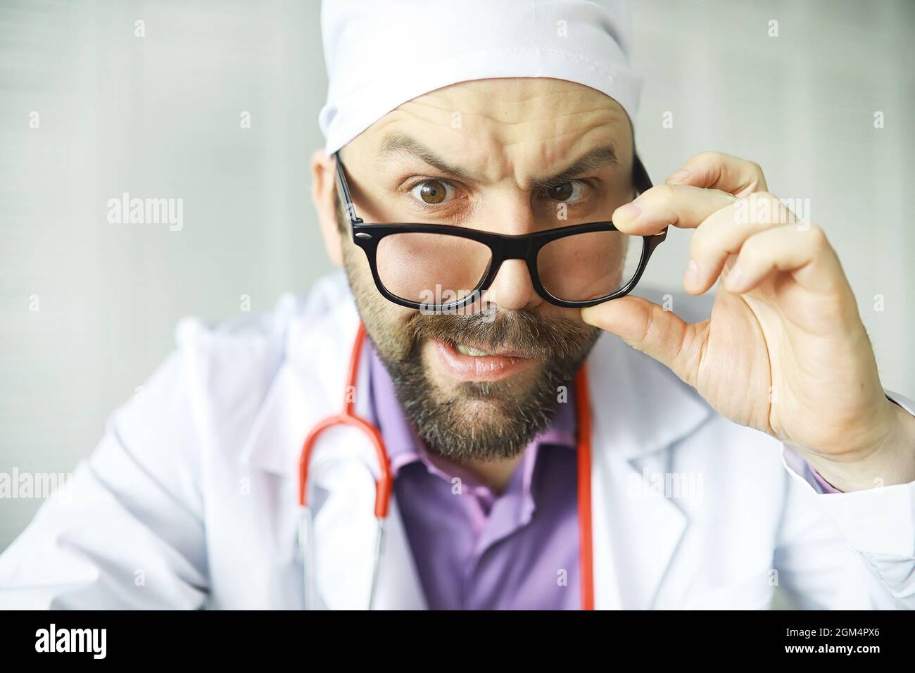 A cross-eyed bearded man is looking into the frame. Eye disease. The ...