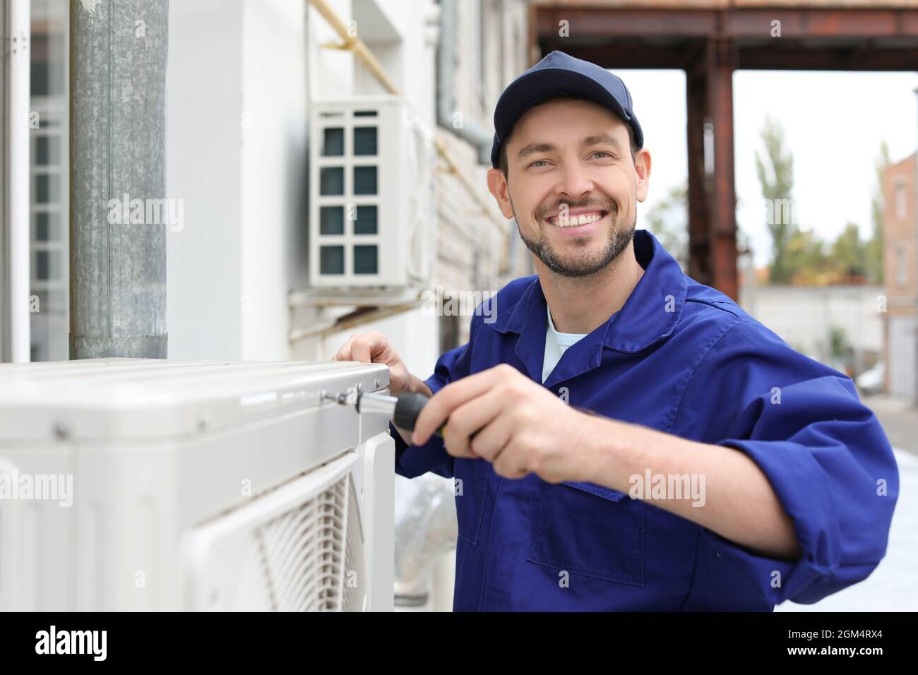 Male technician repairing air conditioner outdoors Stock Photo - Alamy