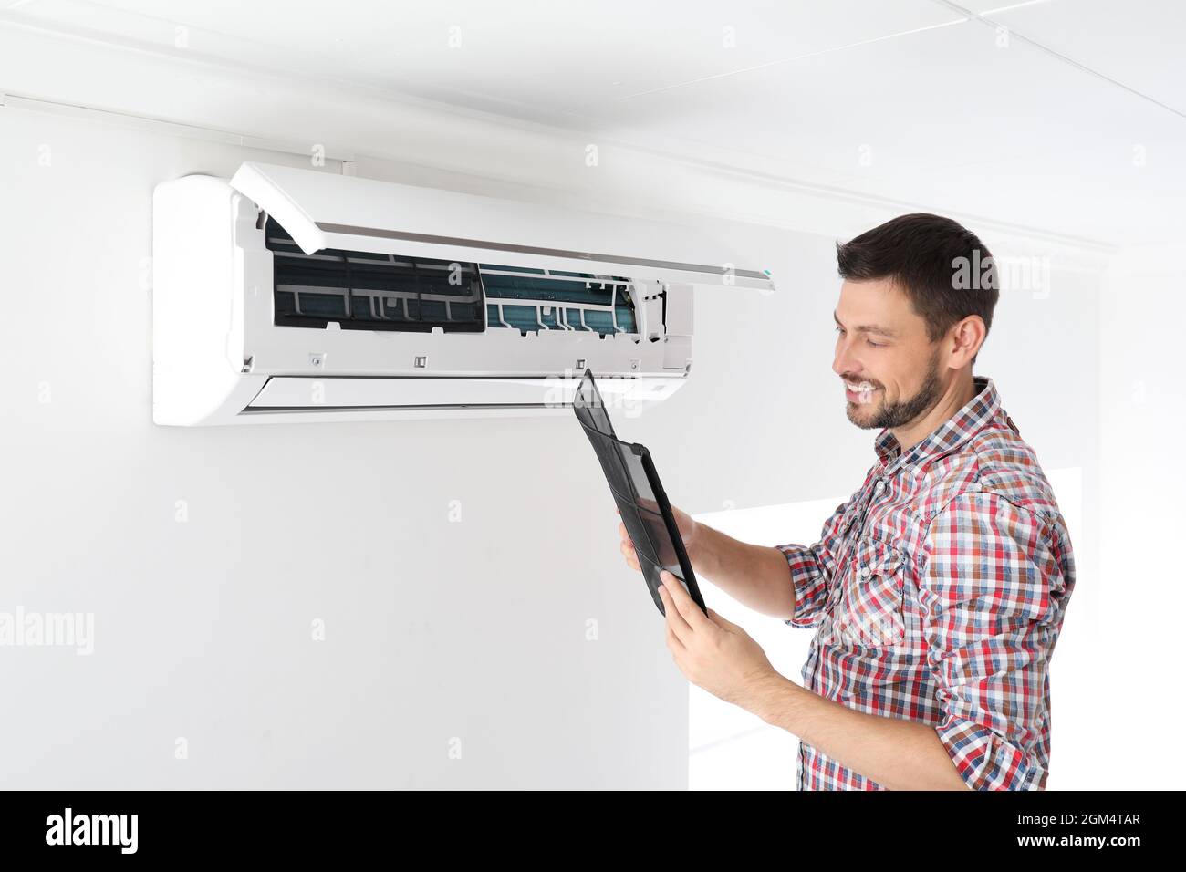Man cleaning air conditioner indoors Stock Photo - Alamy