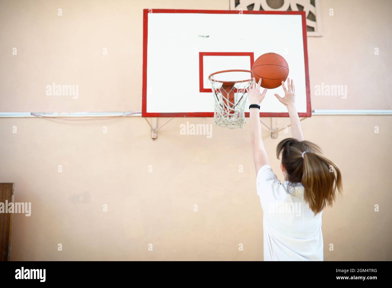 Girl young student in the gym playing a basketball Stock Photo - Alamy