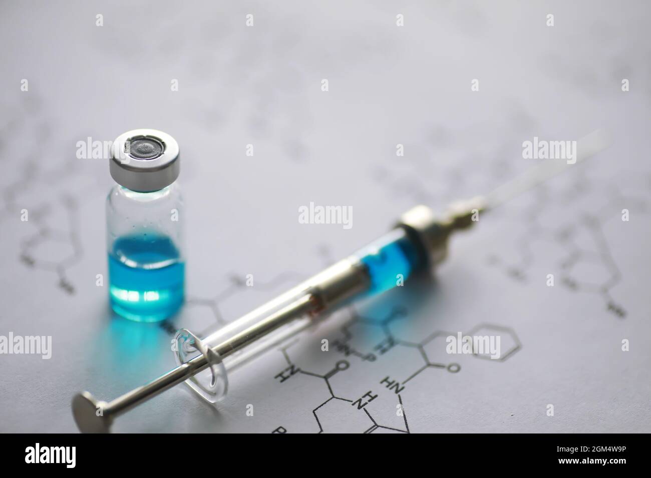 small jars with injection and syringe for injection on blue background ...
