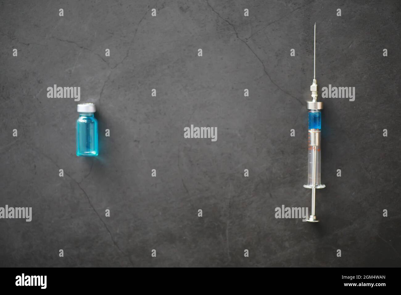 small jars with injection and syringe for injection on blue background ...