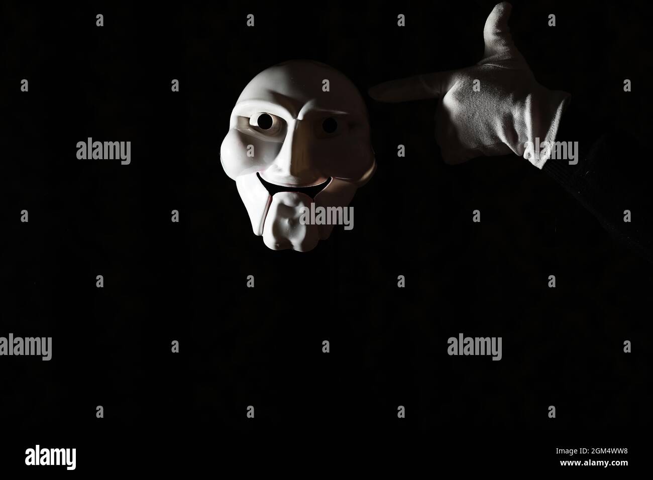 White scary mask on a black background with whites hands Stock Photo ...