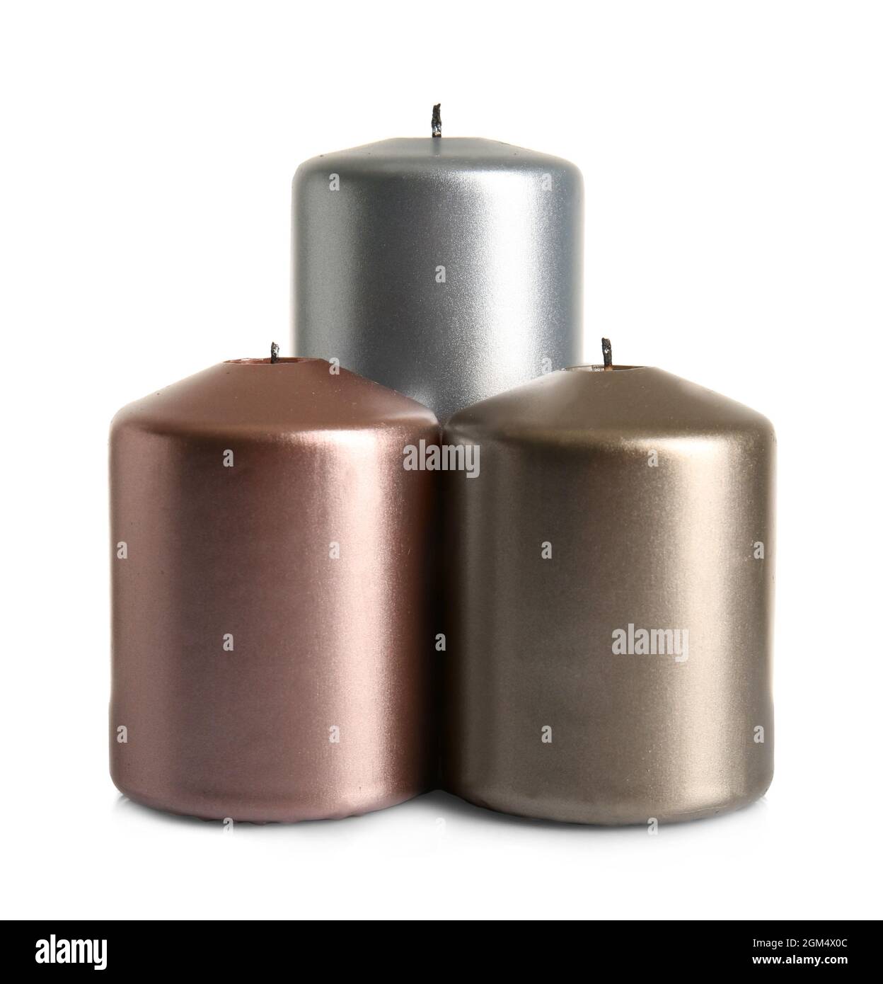 Metallic pillar candles on table against white background Stock Photo ...