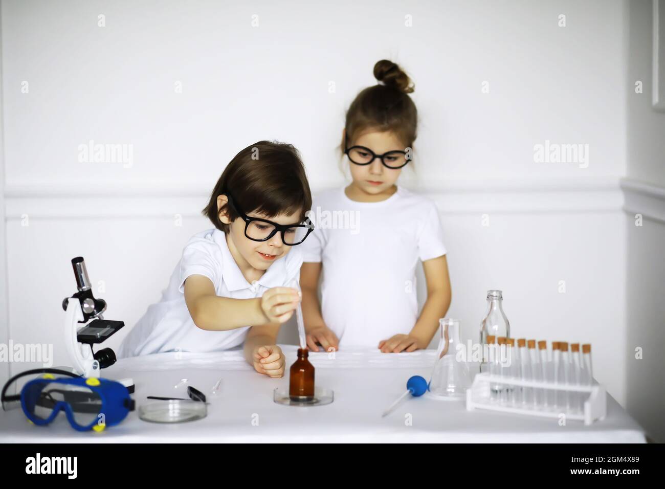 Two cute children at chemistry lesson making experiments isolated on ...
