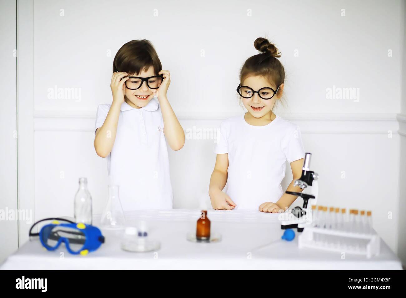 Two cute children at chemistry lesson making experiments isolated on ...