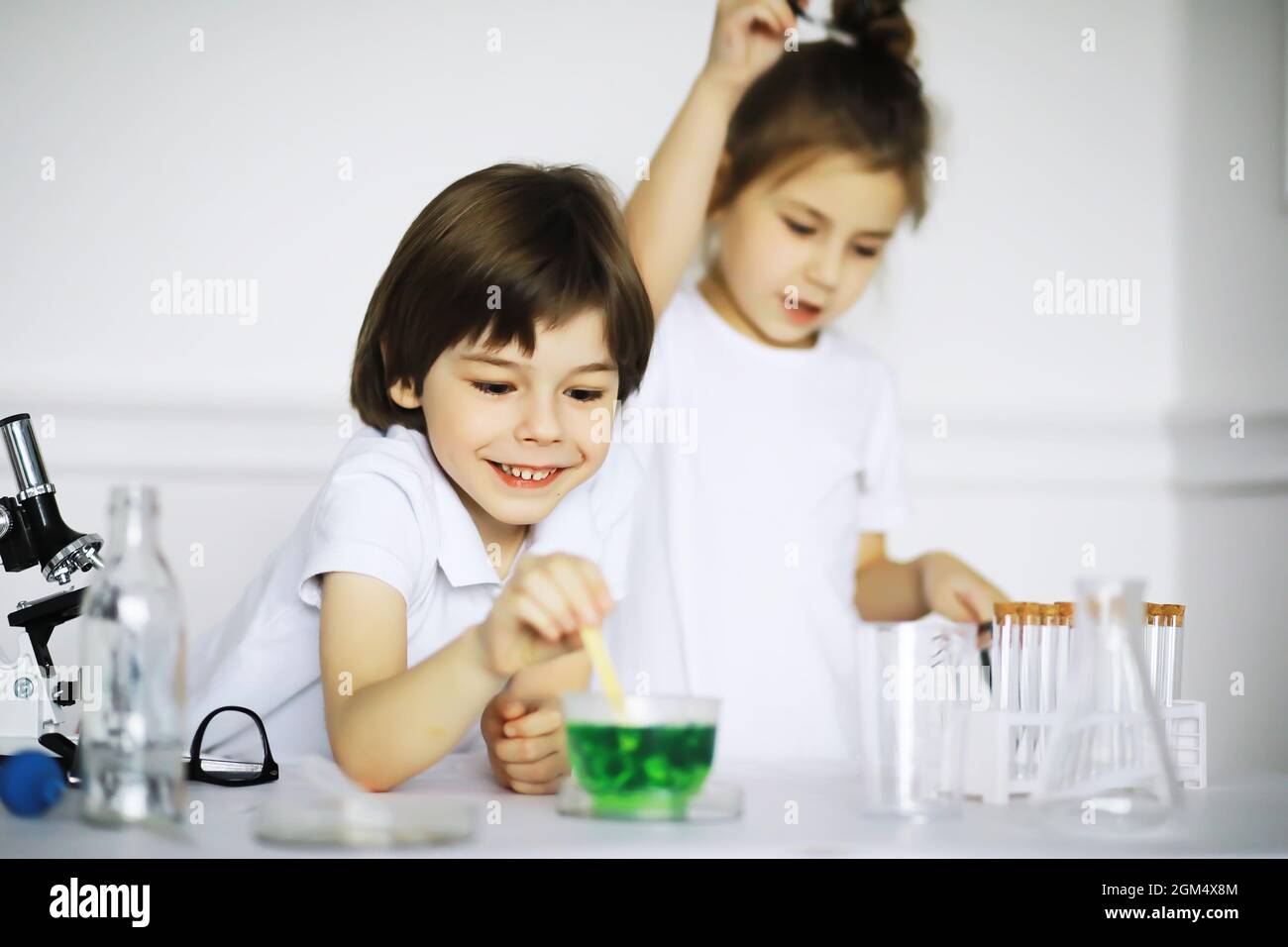 Two cute children at chemistry lesson making experiments isolated on ...