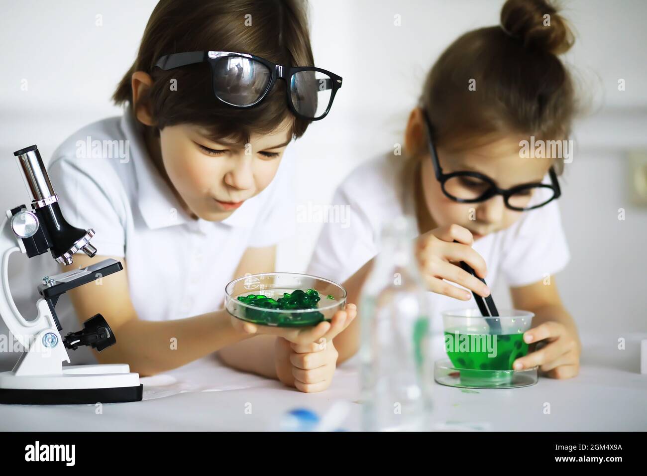Two cute children at chemistry lesson making experiments isolated on ...