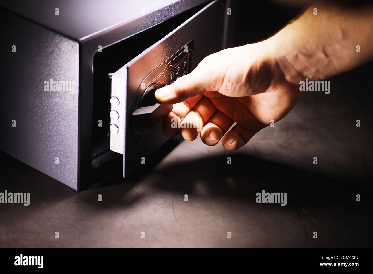 Steel safe with money. Hand putting password in the safety money box in ...