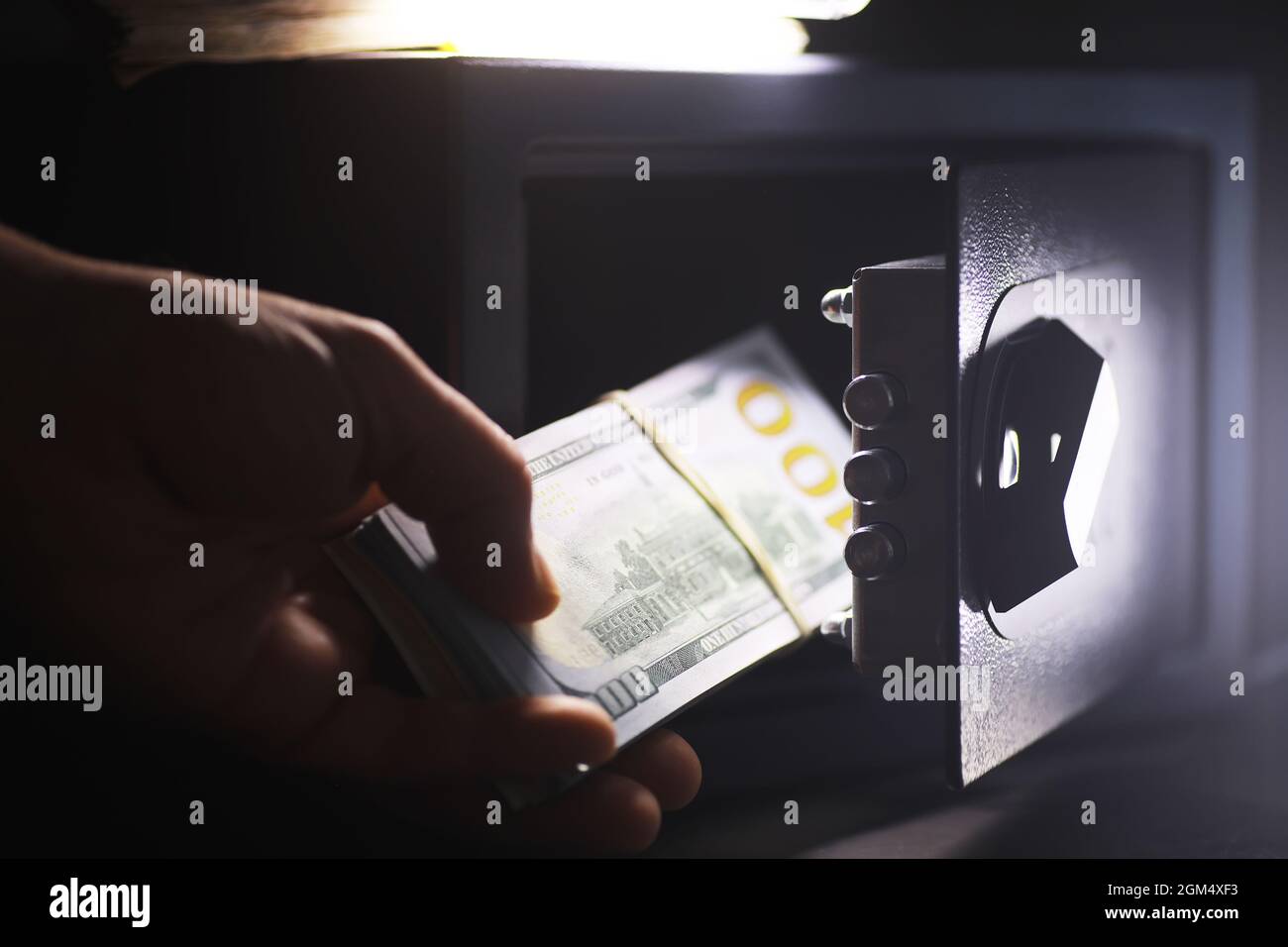 Steel safe with money. Hand putting password in the safety money box in ...