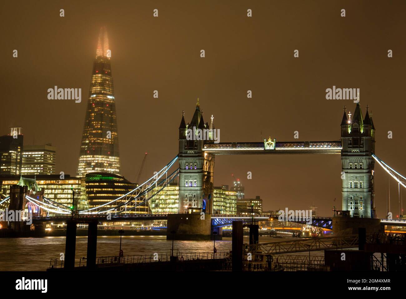 Tower Bridge and the Shard of London on a foggy evening with glowing ...
