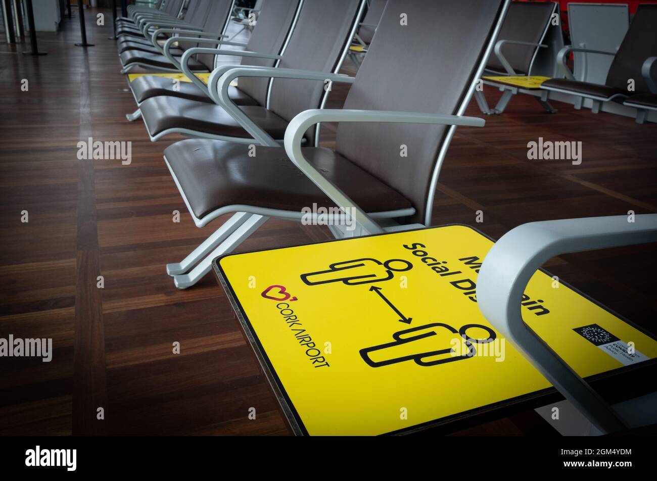 Yellow social distance sign on terminal chairs at airport. Safety ...