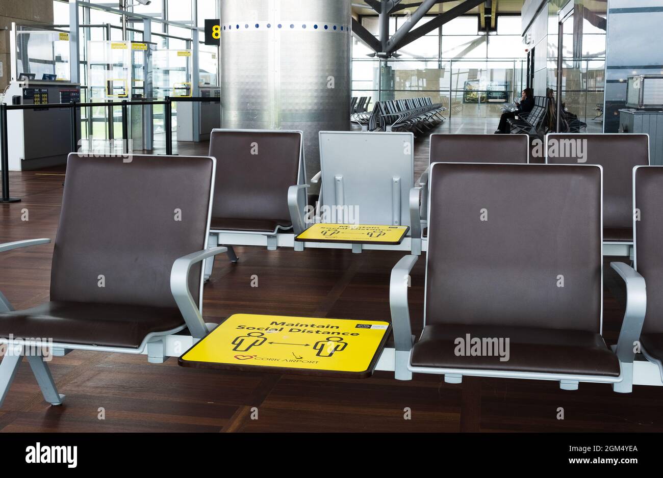 Yellow social distance sign on terminal chairs at airport. Safety ...